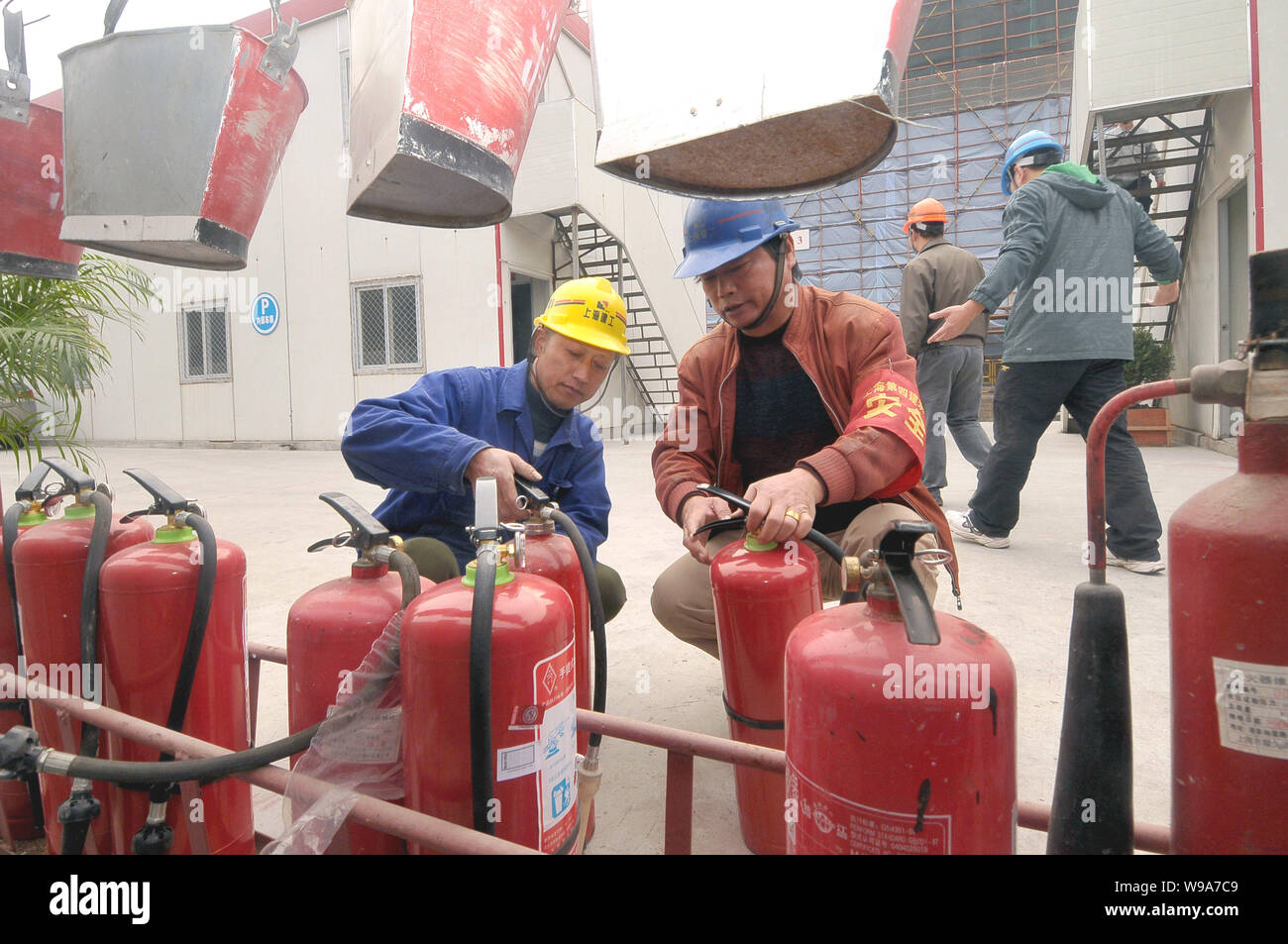 Chinese workers check the fire extinguishers and other firefighting ...