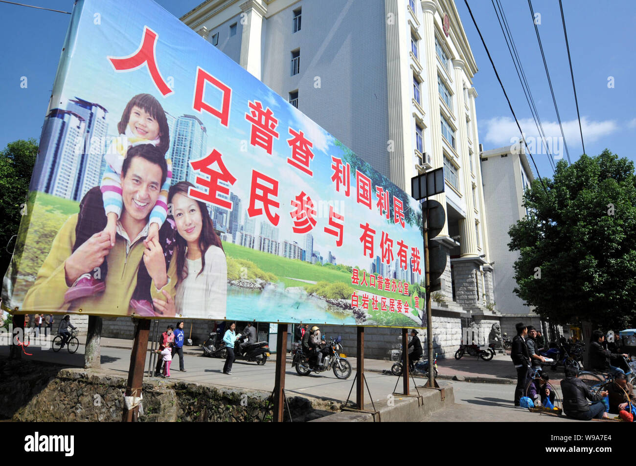 Local Chinese residents walk past a propaganda poster for the Sixth ...