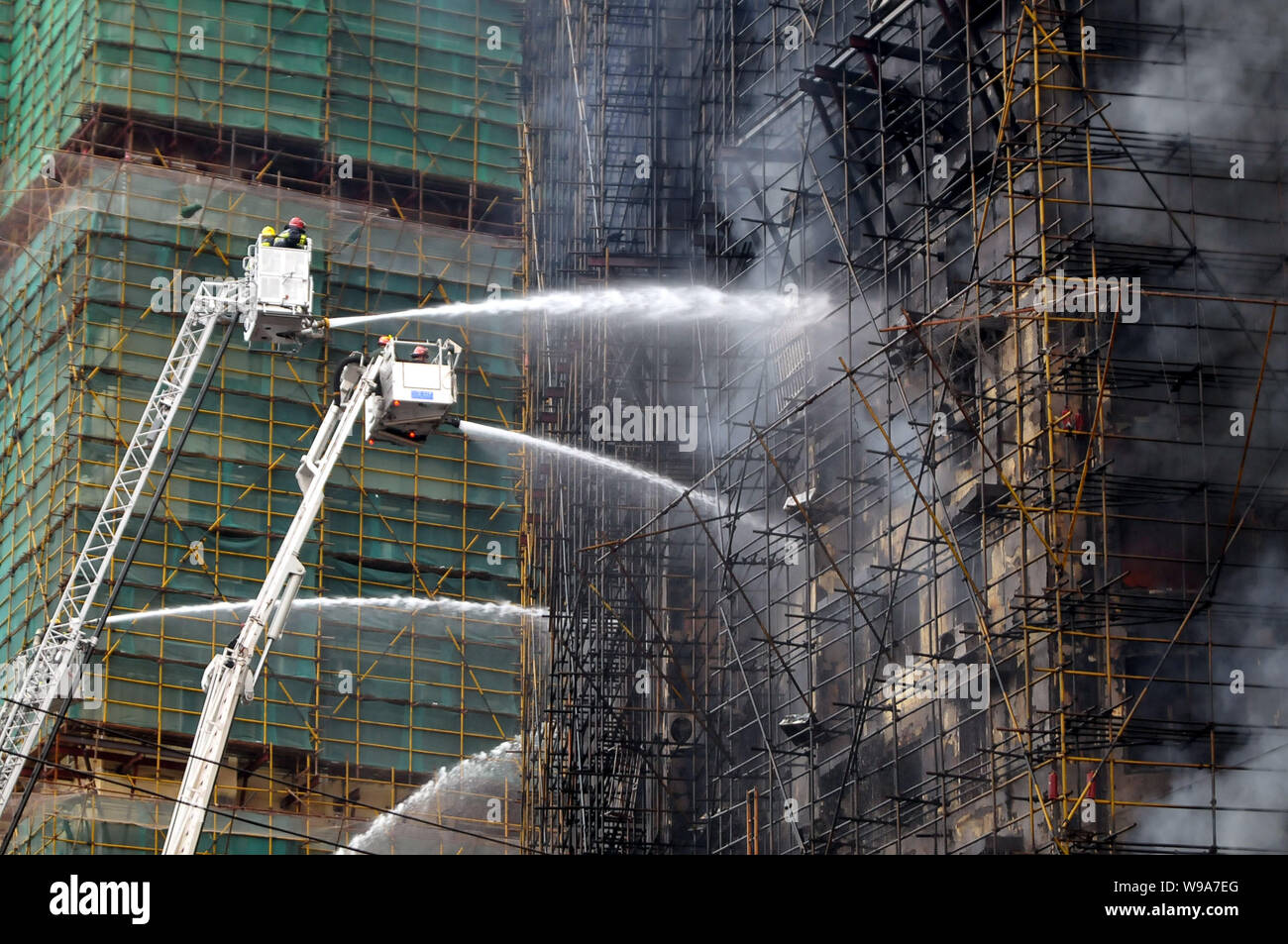 Chinese firefighters hose water to extinguish the fire in a residential ...