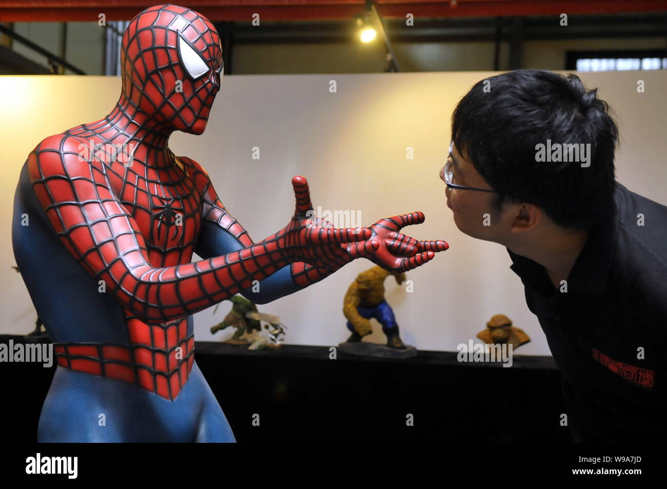 A Chinese visitor looks at a model of the Spider-man during the ...