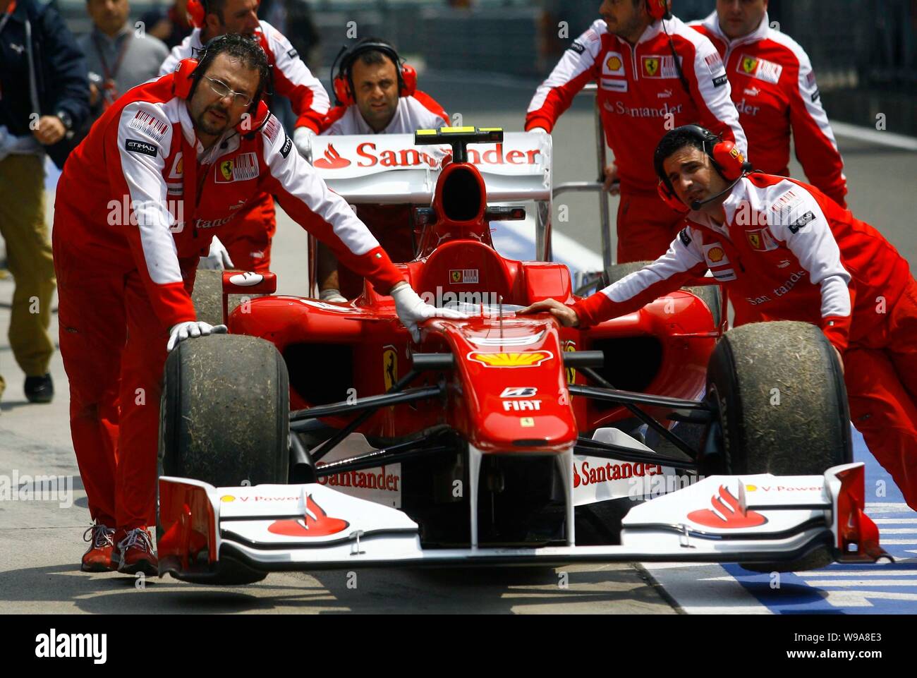 Ferrari team staff pulls a race car during the free practice session at ...