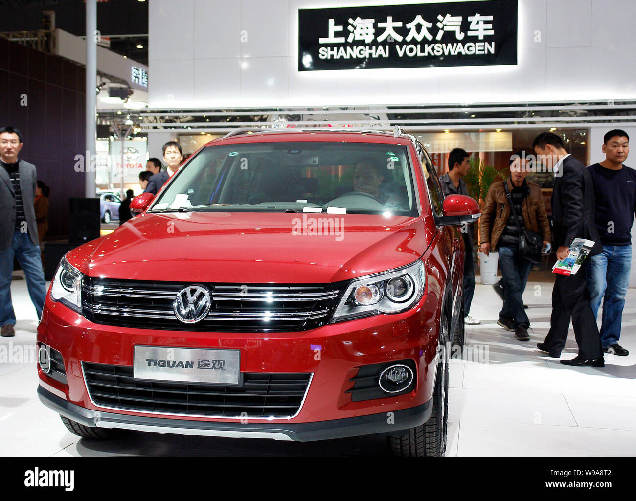 Chinese car buyers look at a Tiguan of Shanghai Volkswagen during an ...