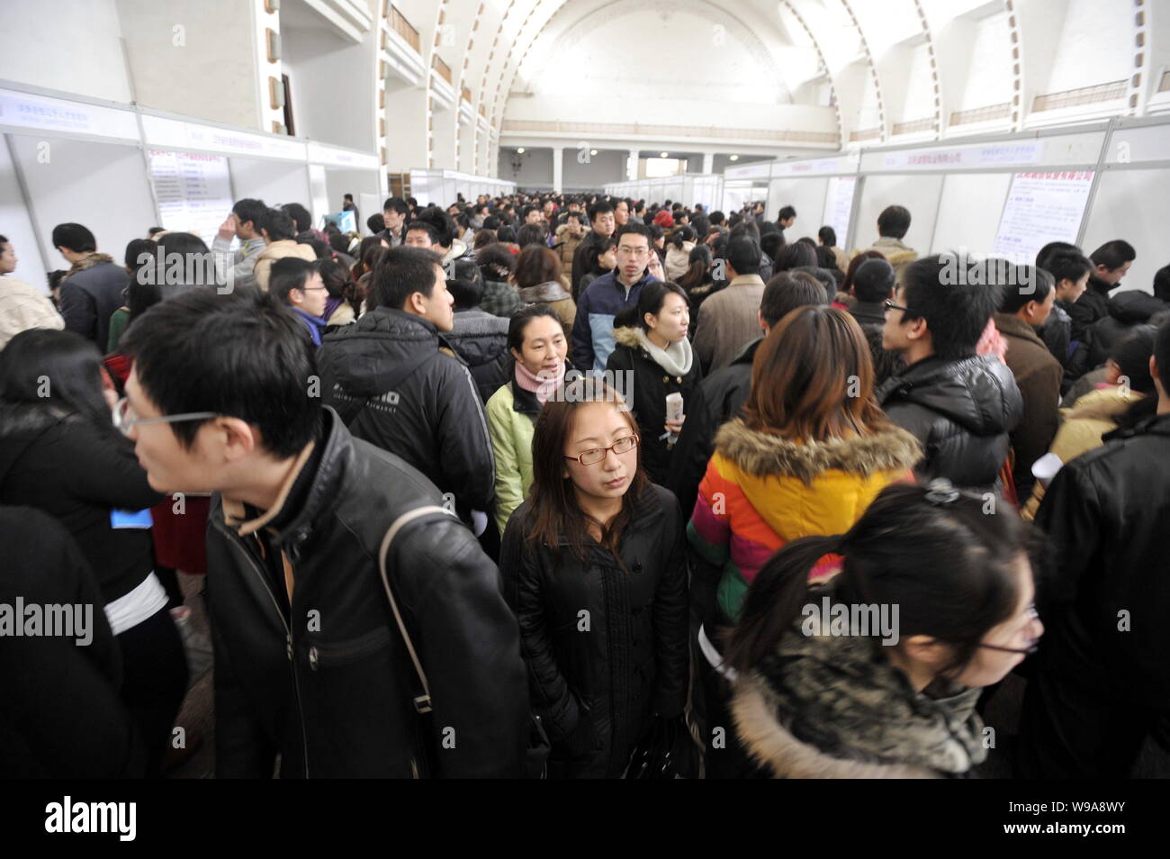 Chinese job seekers crowd booths at a job fair in Shenyang city ...
