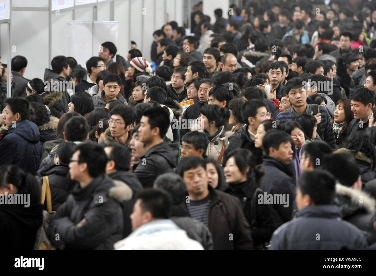 Chinese job seekers crowd booths at a job fair in Shenyang city ...