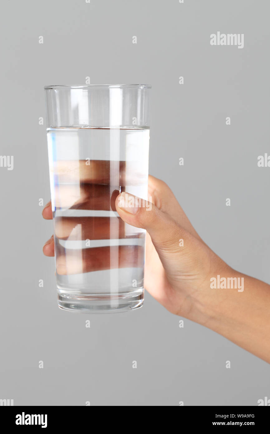Close up of a person hand holding glass of water Stock Photo - Alamy