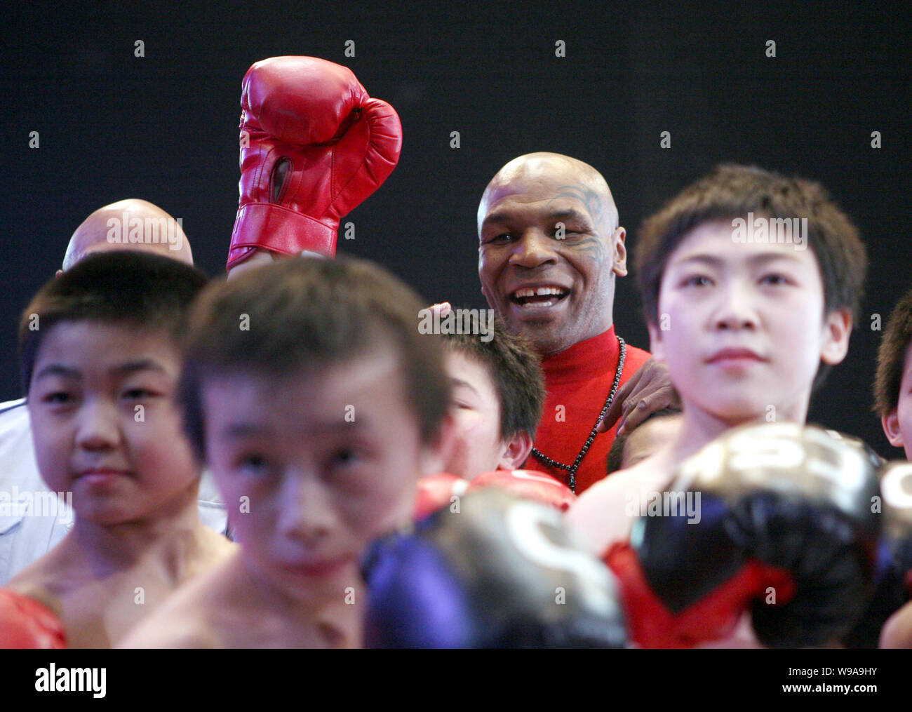 U.S. boxer Mike Tyson poses with young boxers during the First Tianjin ...