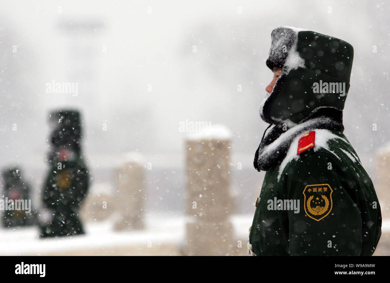 Chinese paramilitary policemen stand guard in a heavy snow at the ...
