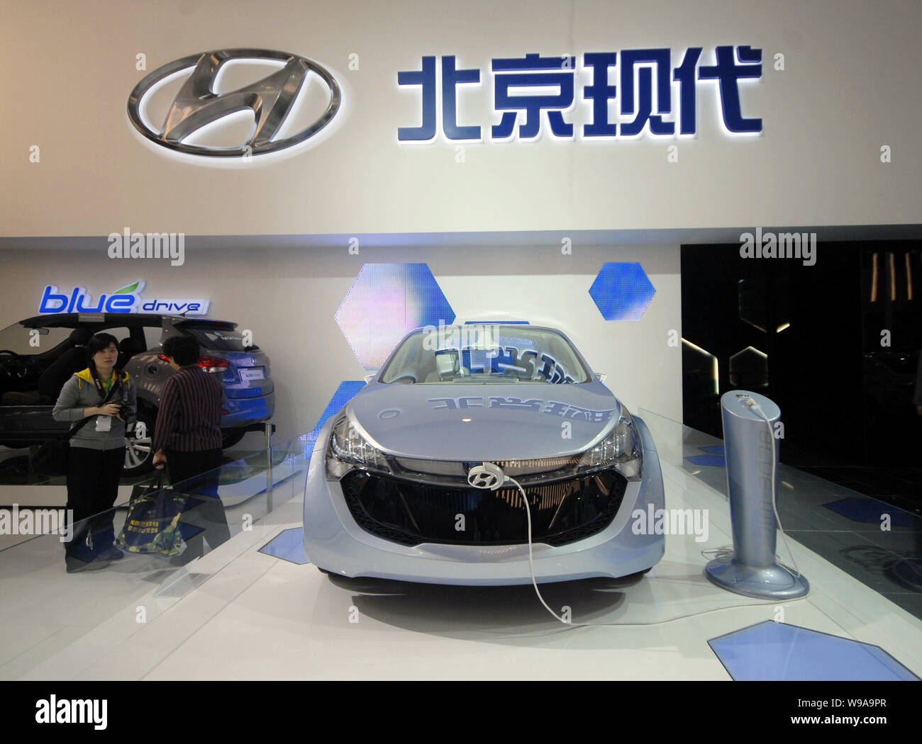 Chinese car buyers look at a Hyundai car during an auto show in Beijing ...