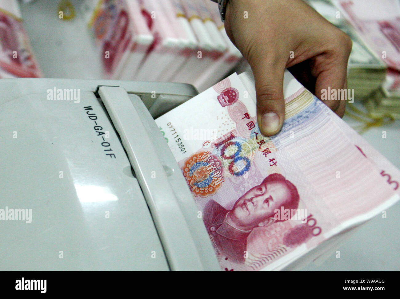 --FILE--A Chinese clerk counts RMB (renminbi) yuan banknotes at a bank ...