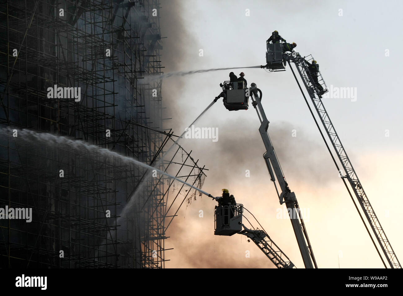 Chinese firefighters hose water to extinguish the fire in a residential ...