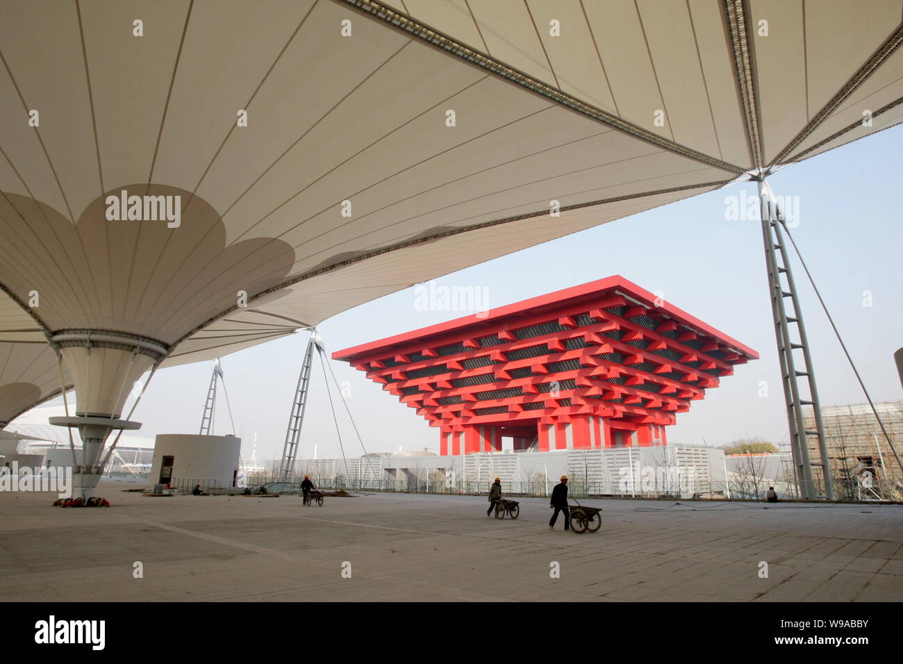 Chinese construction workers push carts past the cable-membrane ...