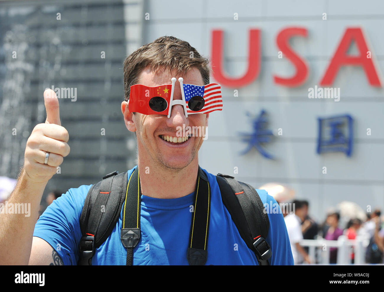 A visitor wearing a pair of glasses with images of Chinese and US ...