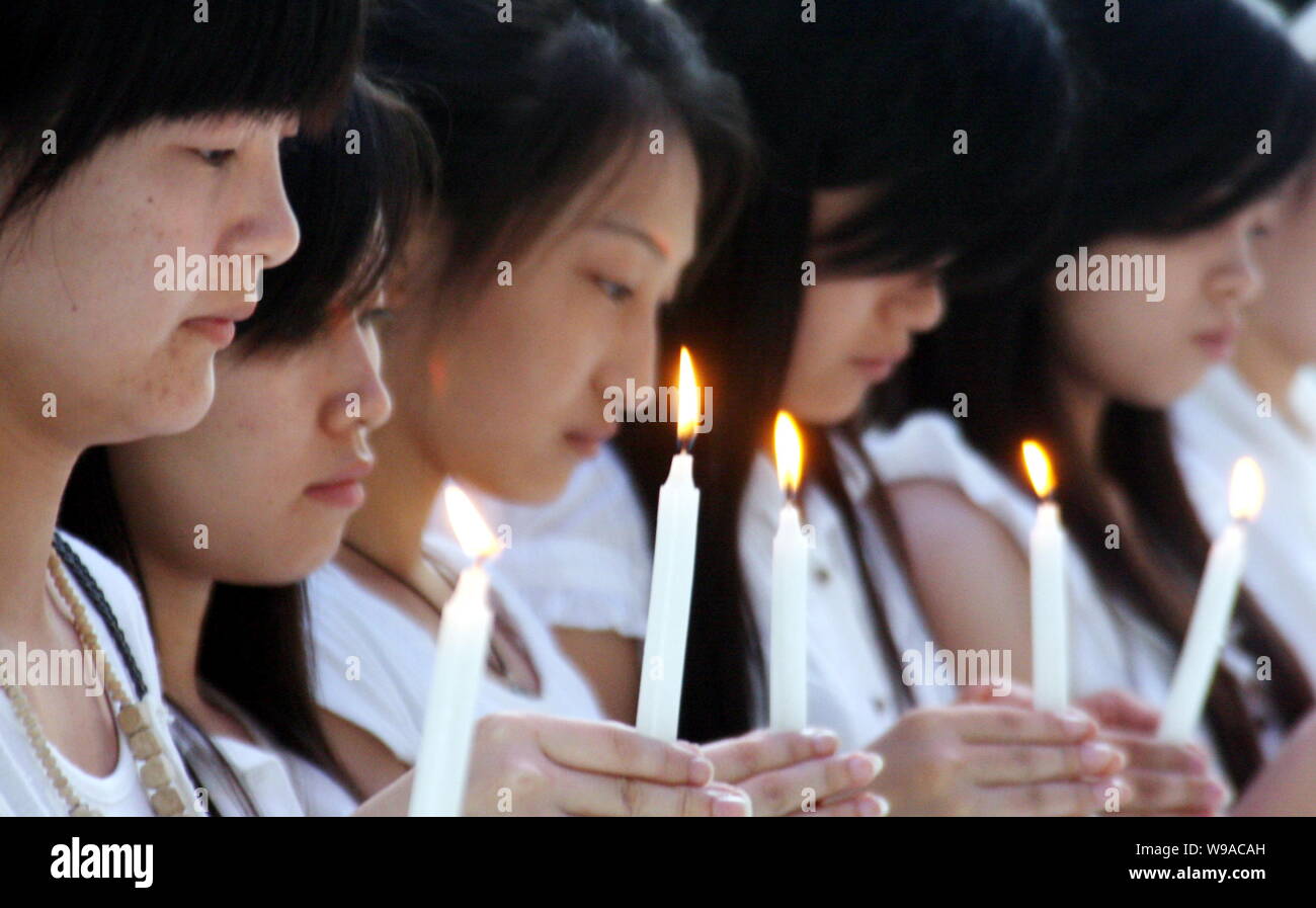Chinese students hold candles to mourn victims of the Zhouqu mudslides ...