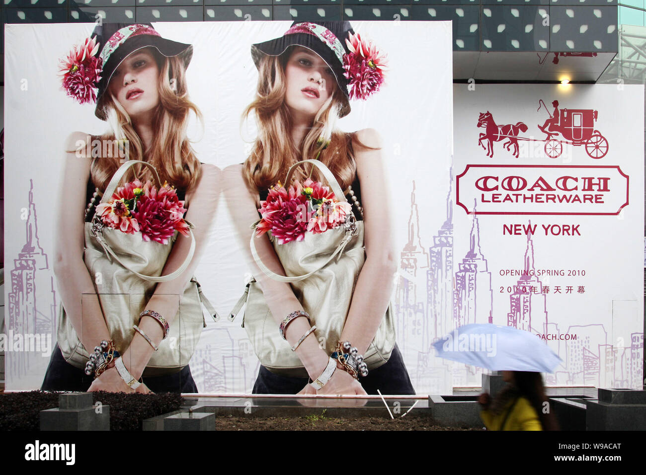 A Chinese woman walks past an advertisement of the upcoming Coach ...