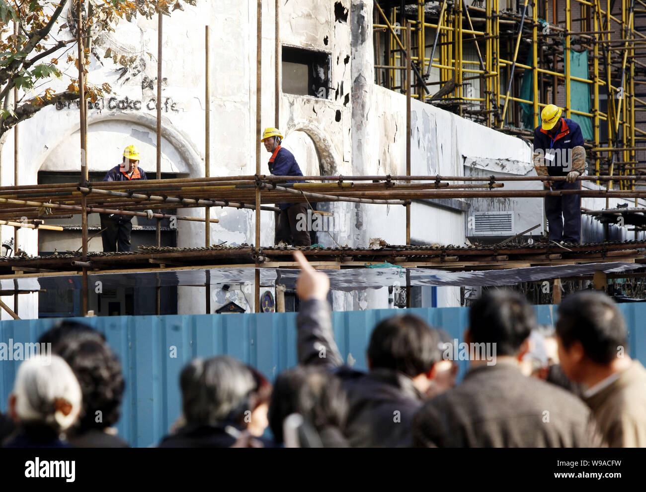 Local residents watch workers dismantling the scaffolding outside the ...