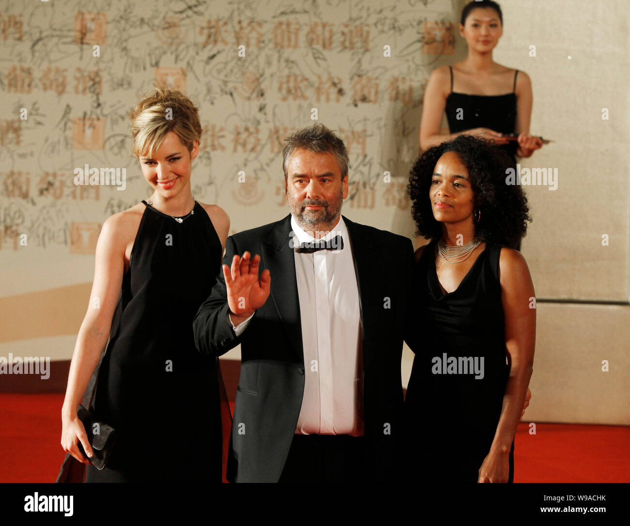 French film director Luc Besson (C) and his wife (R) are seen on the ...