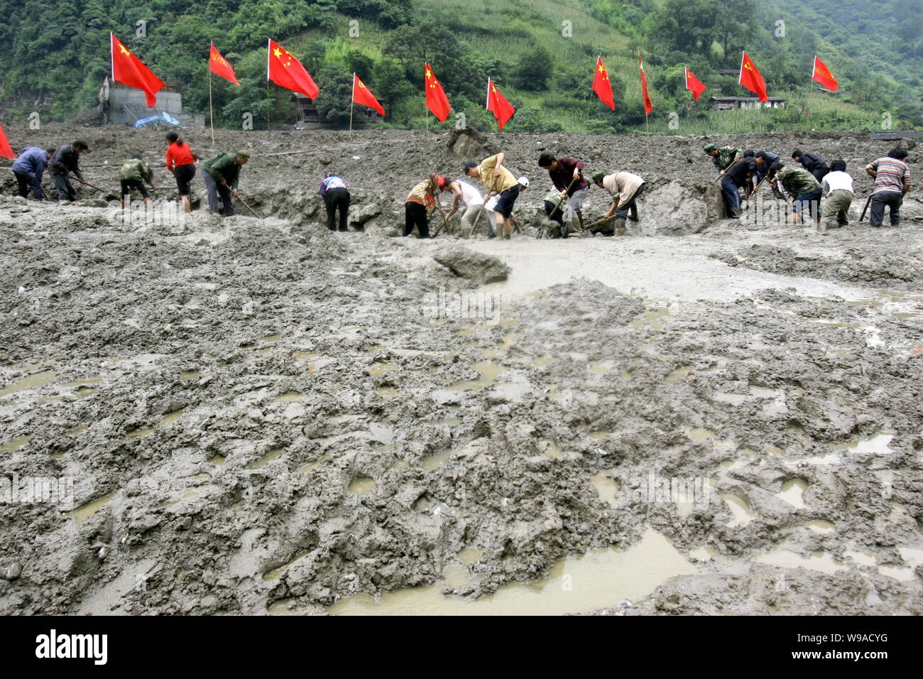 Chinese rescuers try to clean up the mud in the aftermath of the ...