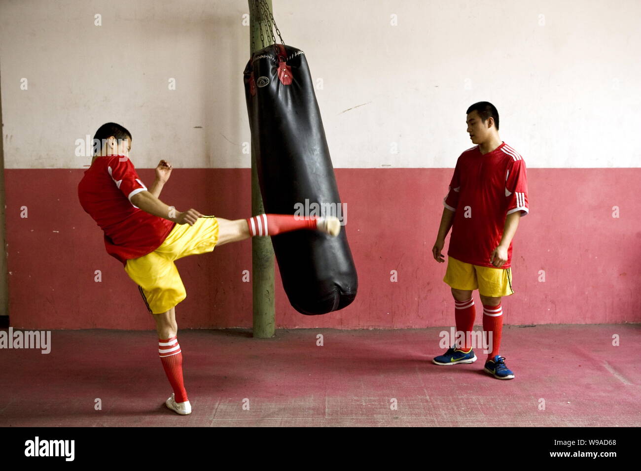 A Chinese kungfu football player kicks a sandbag during a training ...