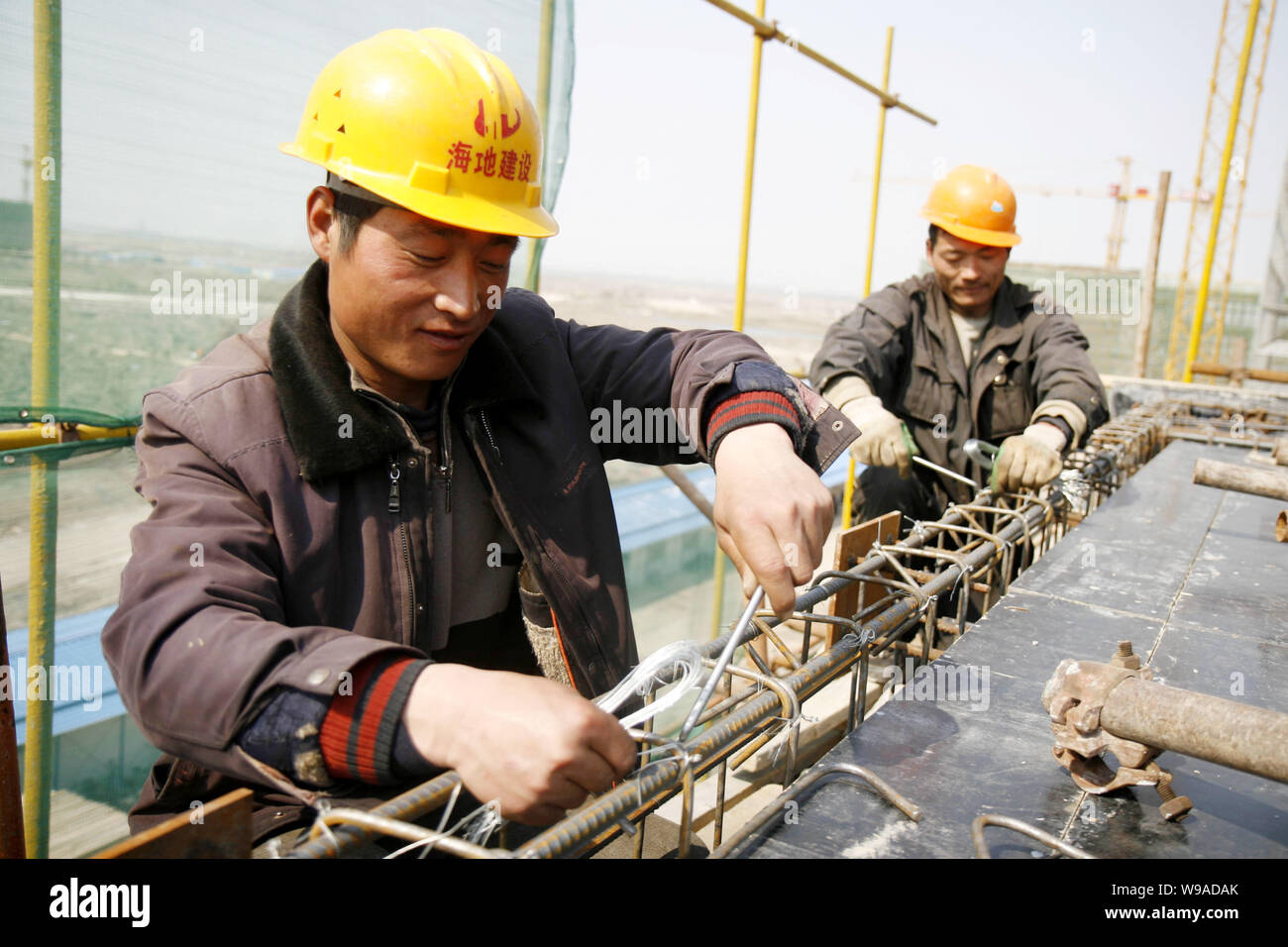 Chinese workers labor on the construction site of the main building of ...