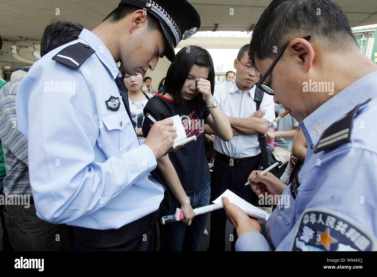 Chinese police officers question the student whose mobile phone is said ...