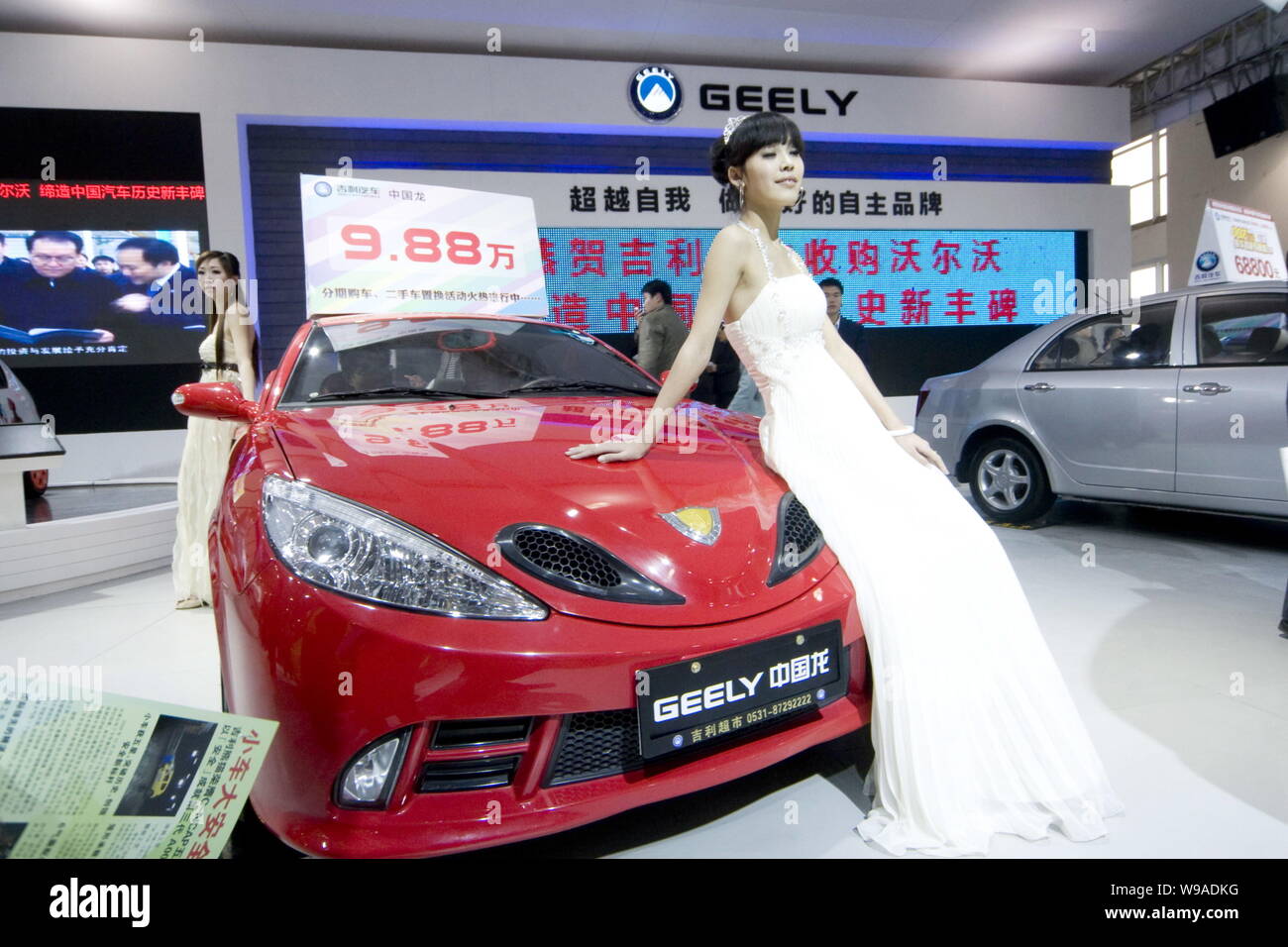--FILE--Chinese models pose next to a Geely China Dragon during an auto ...