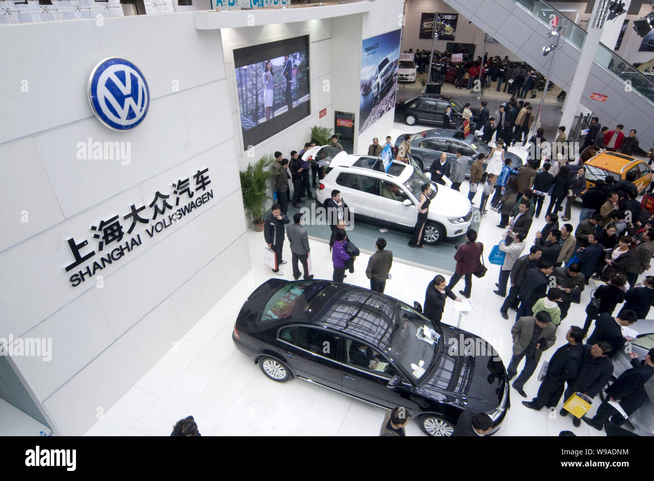 --FILE--Chinese visitors look at cars of Shanghai Volkswagen, the joint ...
