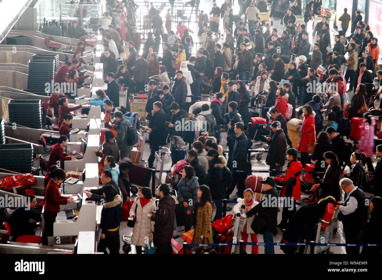 --FILE--Crowds of passengers queue up to get their boarding tickets at ...