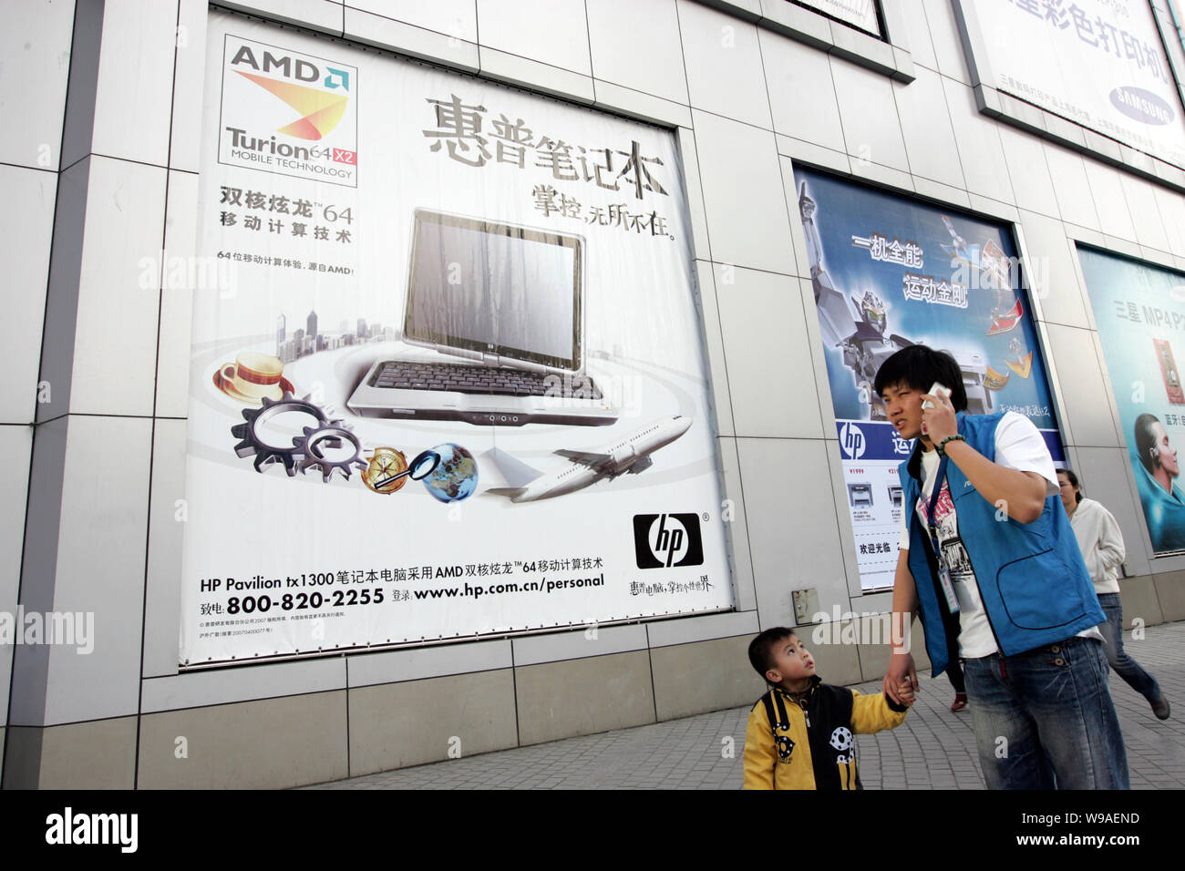 --FILE-- Local residents walk past an advertisement of HP (Hewlett ...