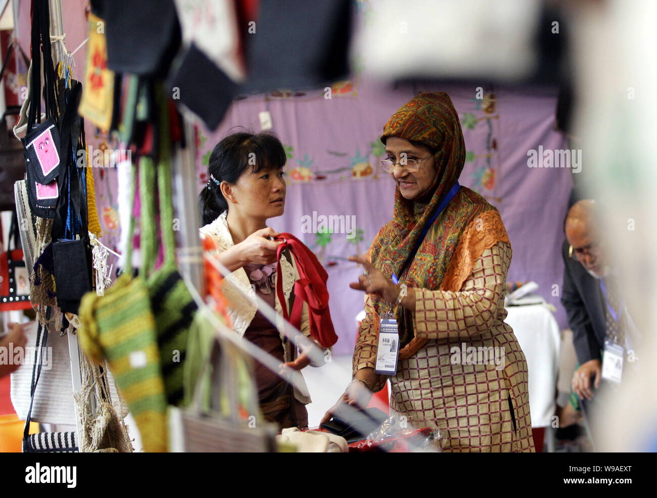 A buyer, left, talks to an exhibitor during the 18th China Kunming ...