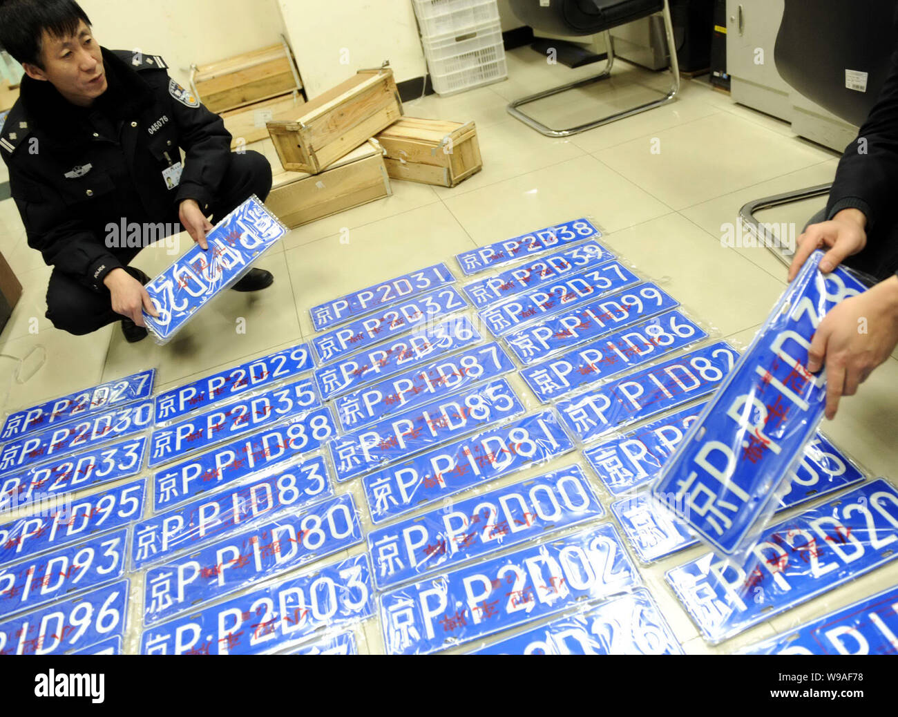 Chinese police officers prepare new car license plates for car owners ...