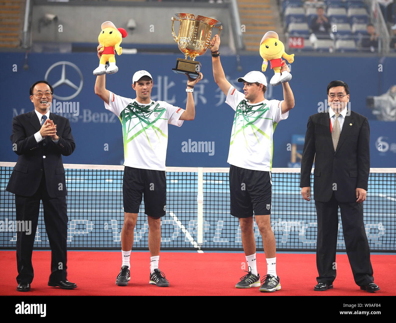 The Bryans of the U.S. (center) pose with the trophy cup after winning ...