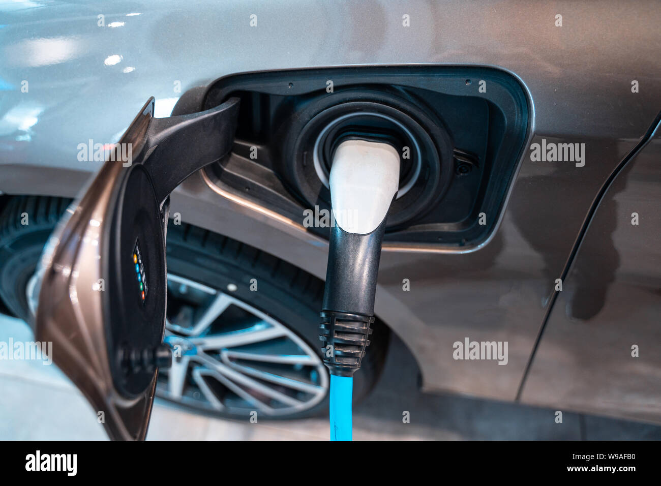 Power supply plugged into an electric car being charged Stock Photo - Alamy