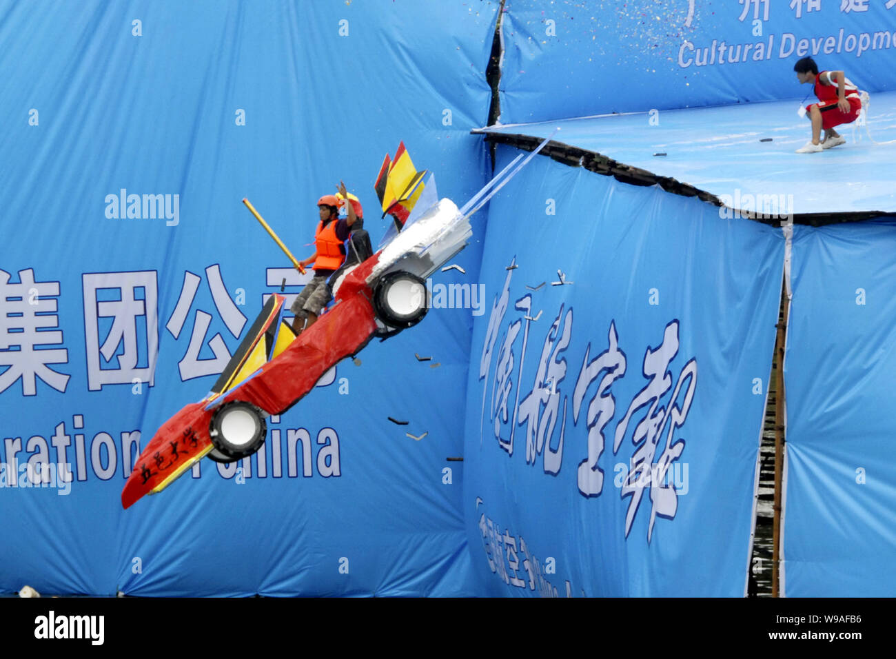 A Chinese participant sitting his homemade model racing car falls into ...