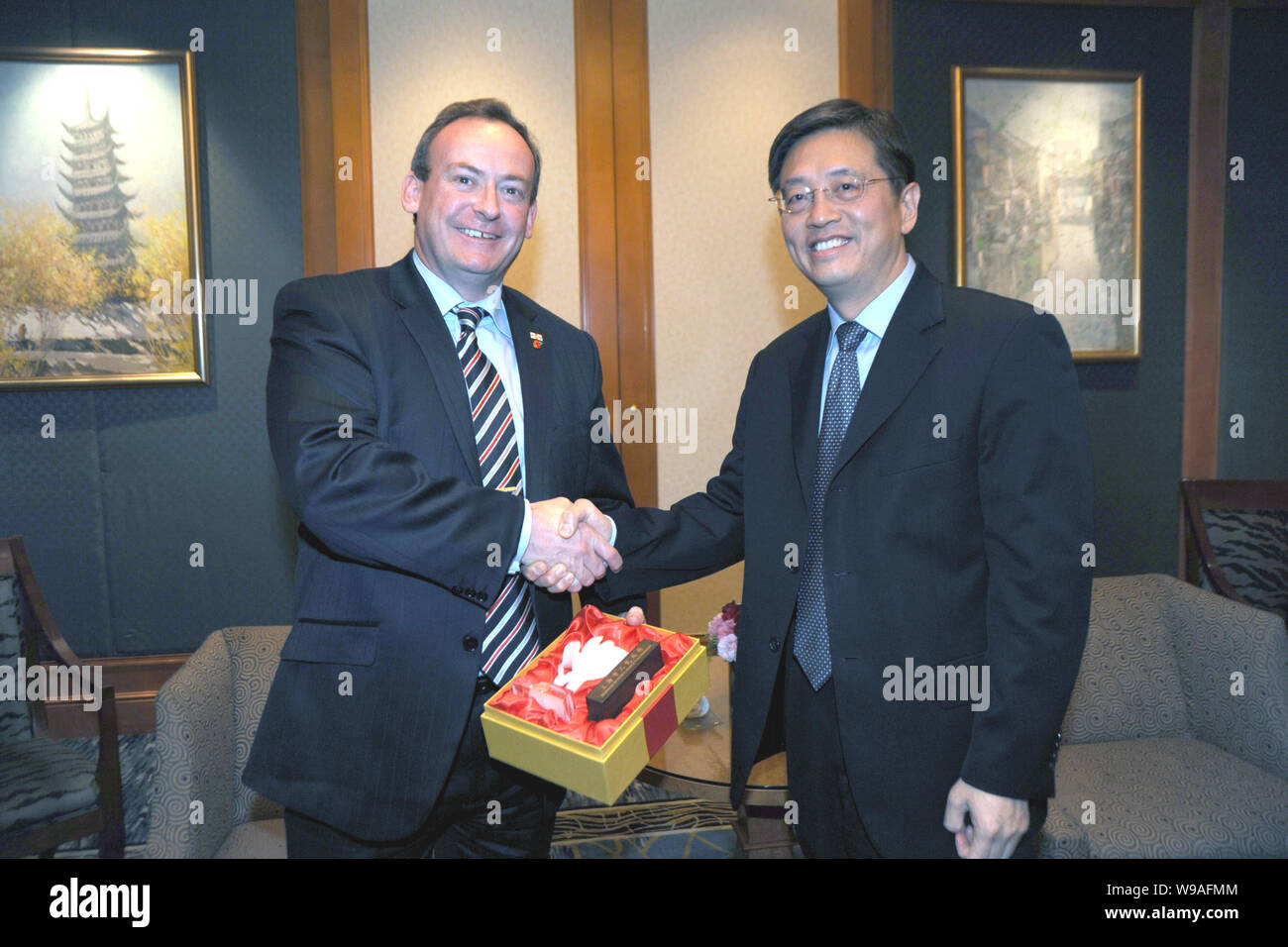 Lyndon Trott (left), Chief Minister of State of Guernsey, shakes hands ...