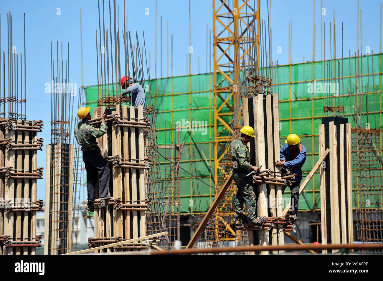 Chinese workers are seen constructing a residential building at the ...