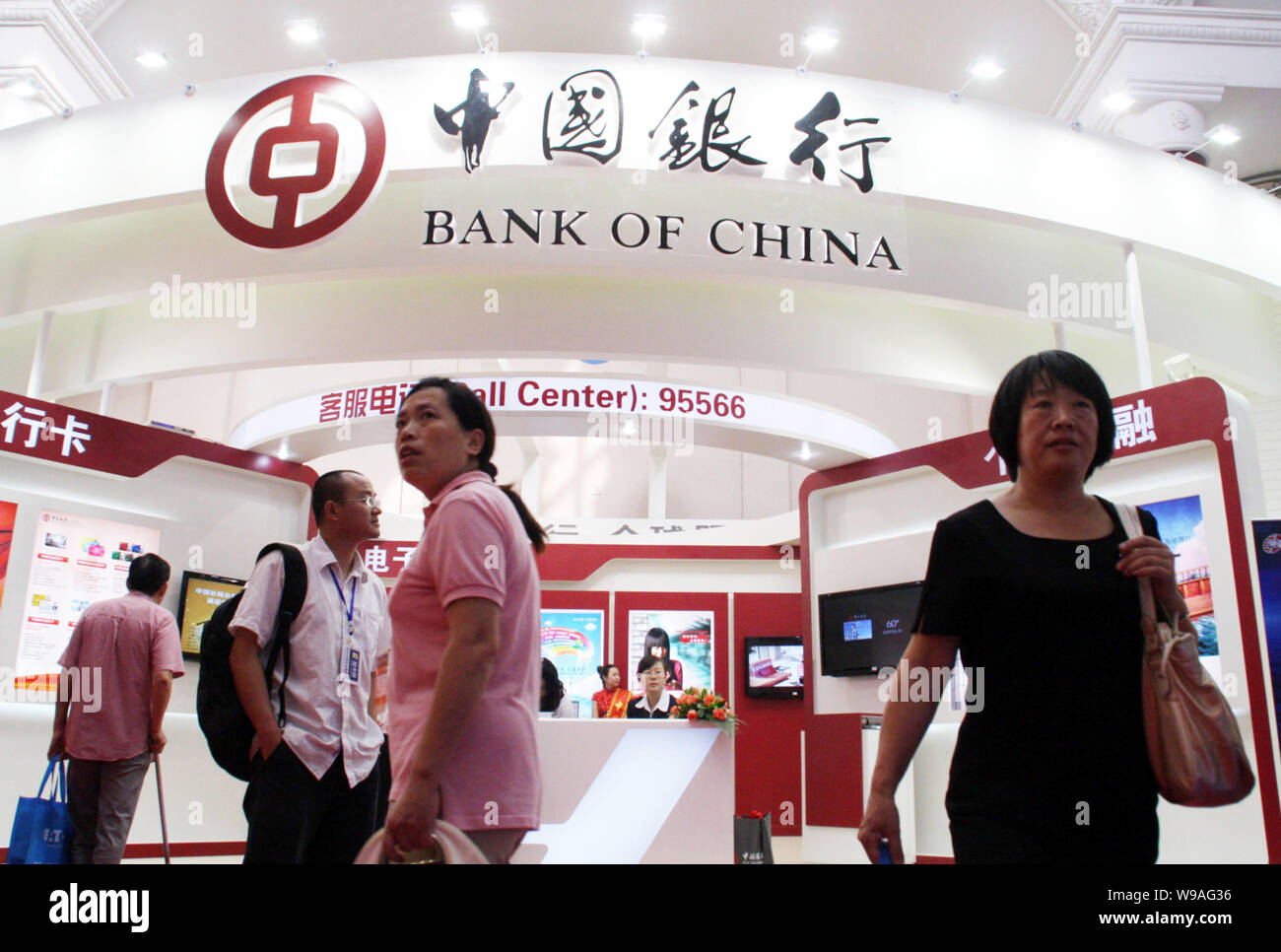 Chinese visitors walk past the stand of Bank of China (BOC) during a ...