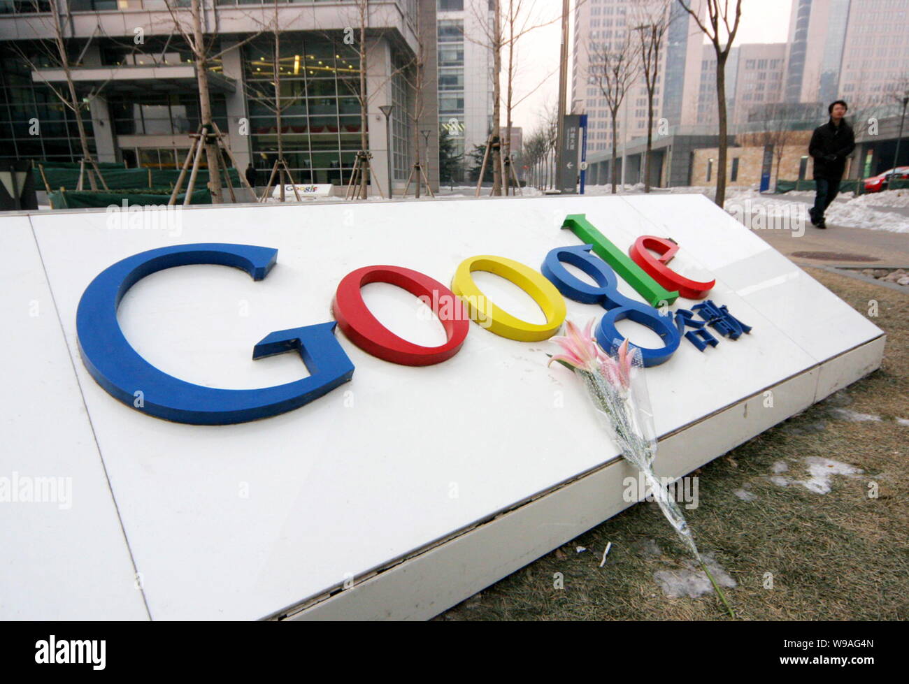 A Chinese man walks past the logo of Google in front of the ...