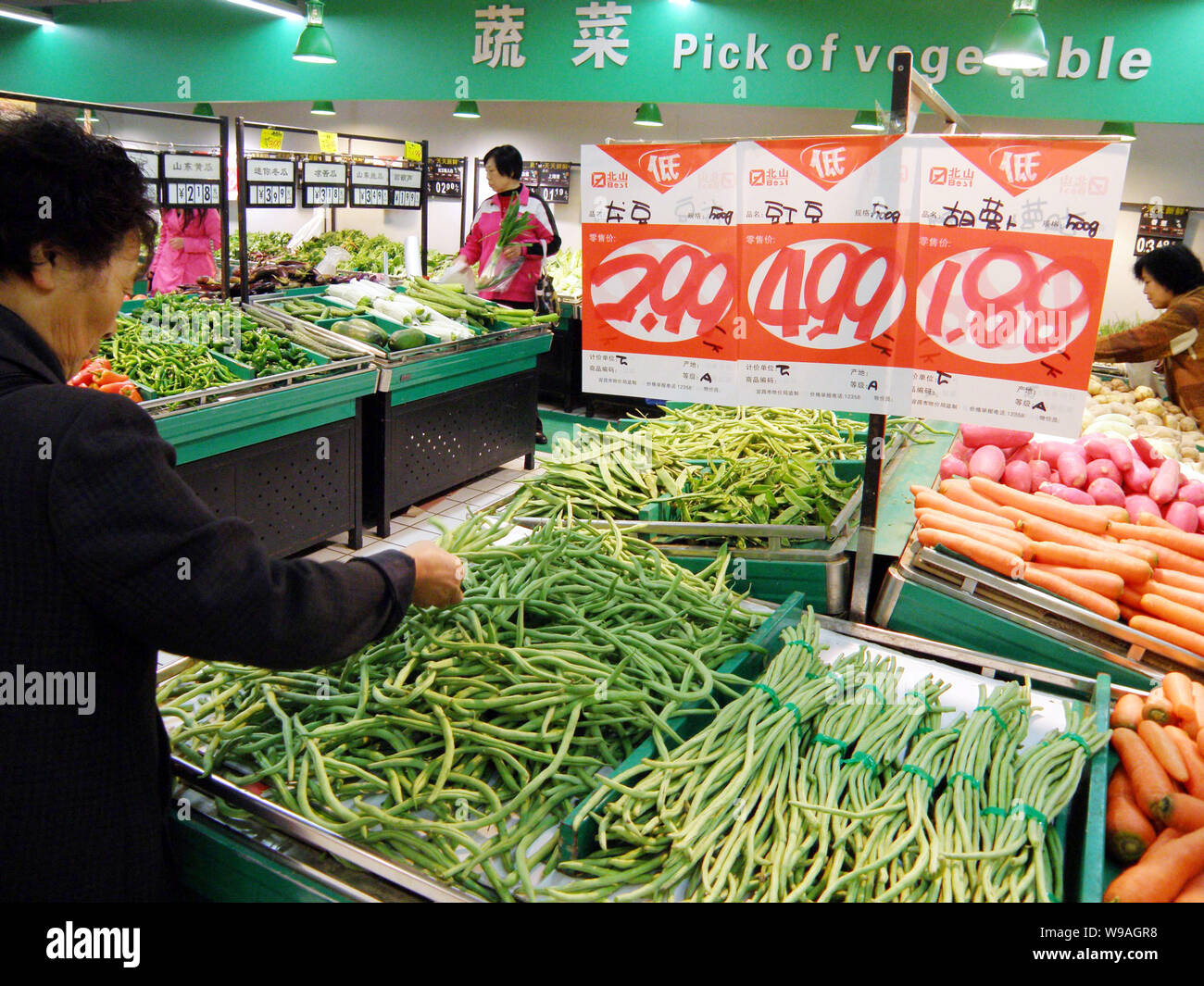 Chinese customers shop for vegetables at a supermarket in Yichang city ...