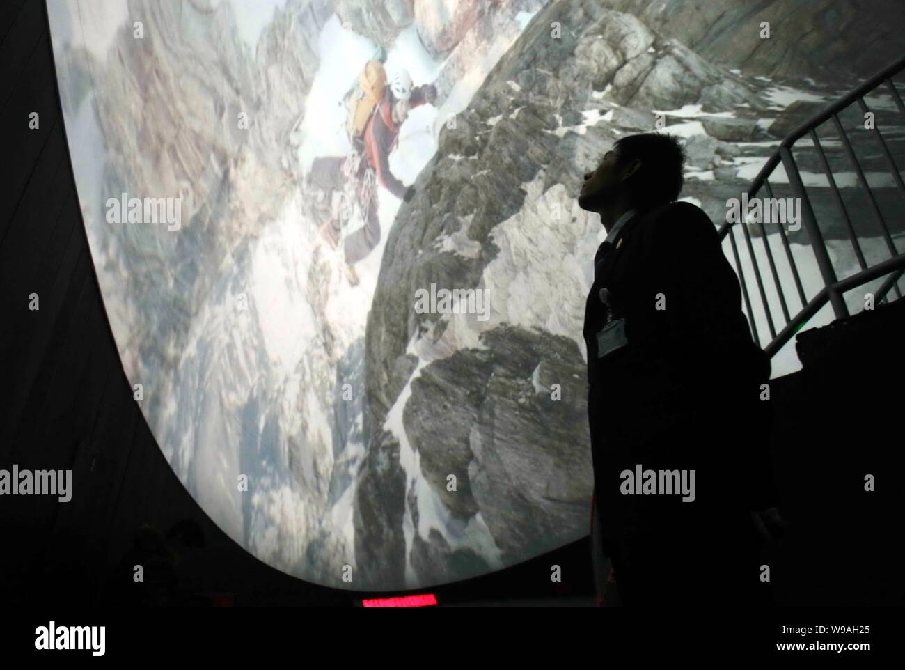 A staff watches the worlds biggest IMAX screen at the new China Science ...