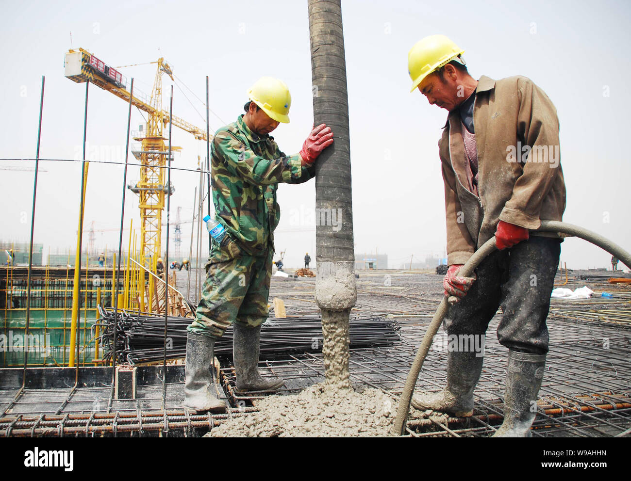 Chinese workers pour concrete on the construction site of the main ...