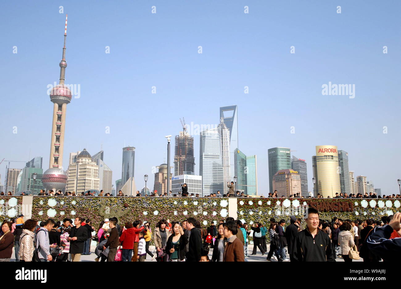 Tourists and local residents crowd the renovated Bund against the ...