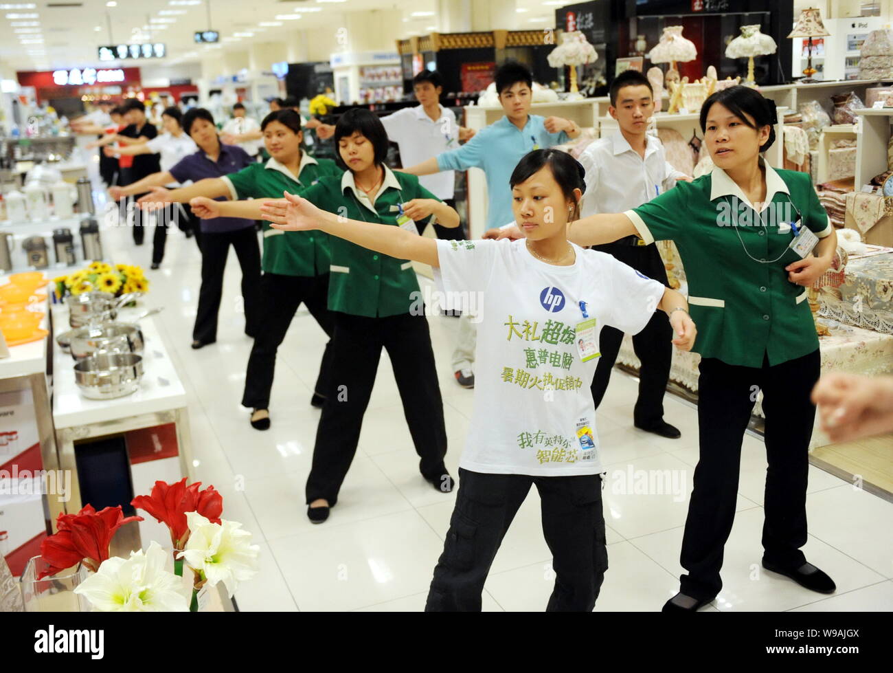 Chinese employees do a synchronized physical exercise at a shopping ...