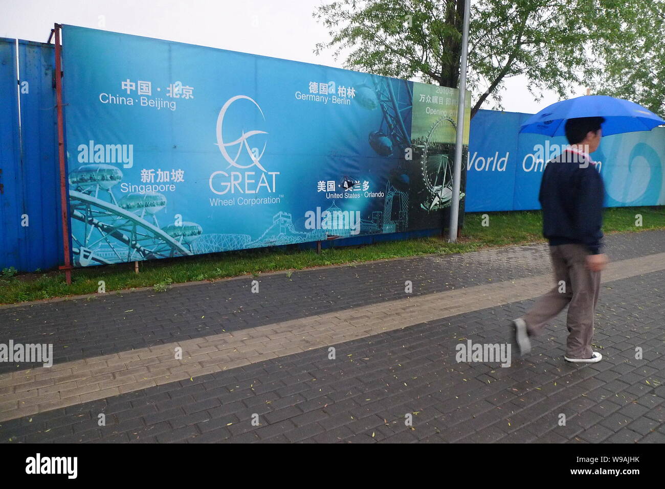 A Chinese man walks past advertising posters of the worlds tallest ...