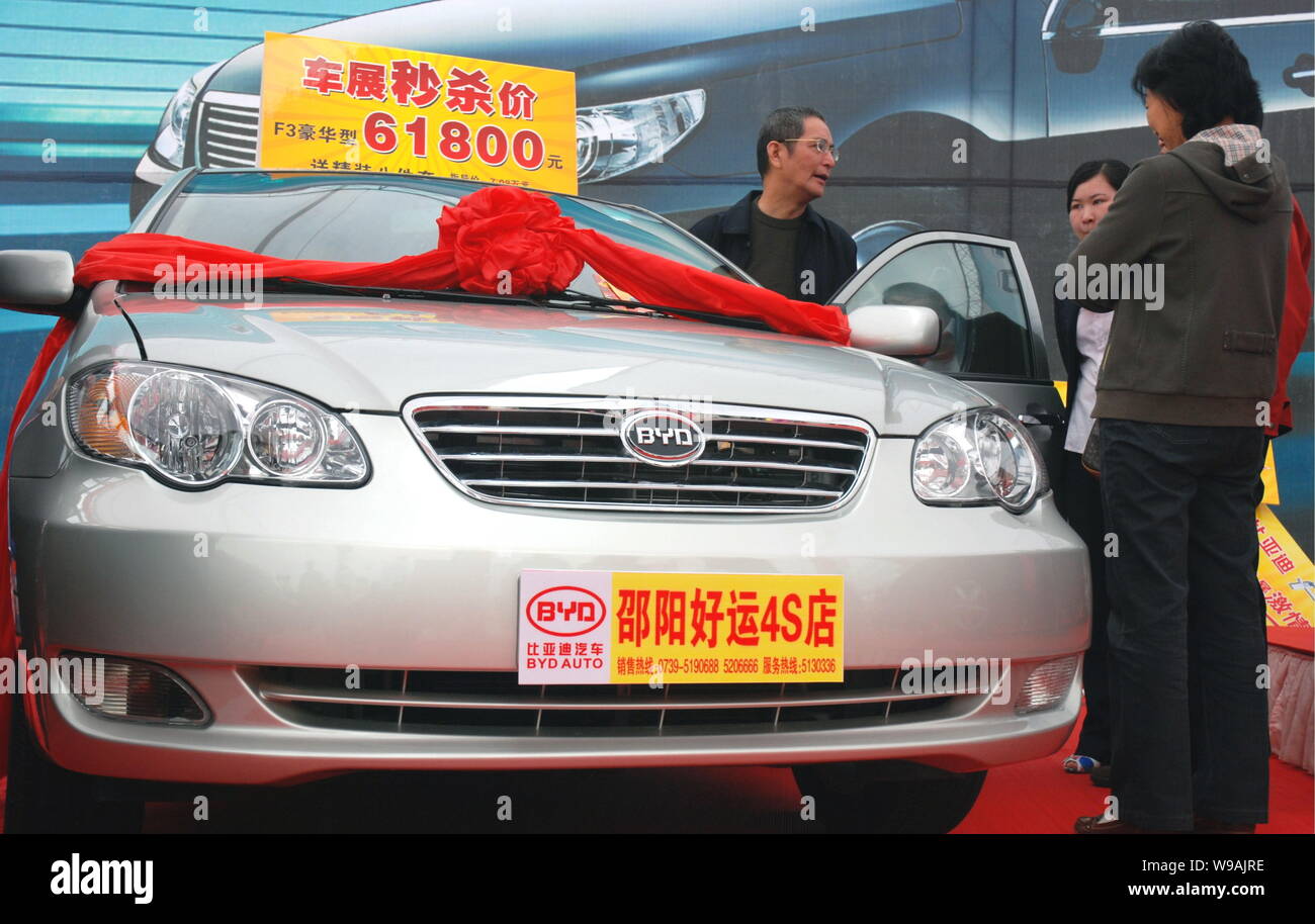 Chinese consumers look at a BYD car during an auto show in Shaoyang ...