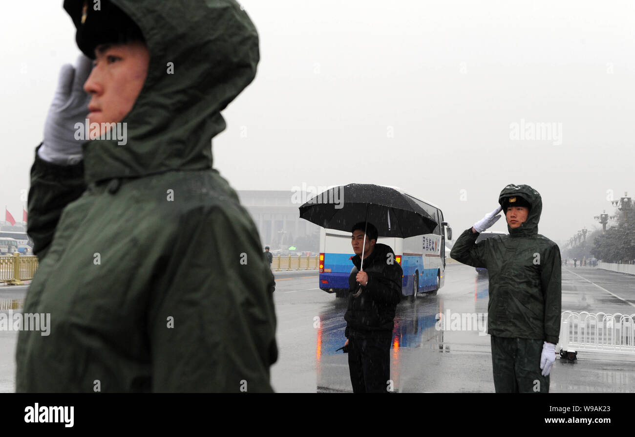 Chinese soldiers salute buses carrying delegations on Tiananmen Square ...
