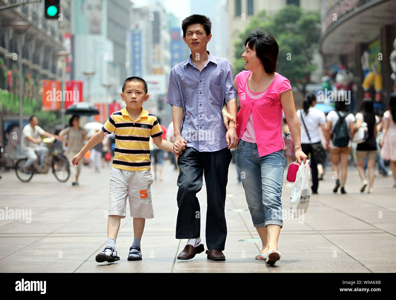 --FILE--A Chinese family of three walk on the Nanjing Road shopping ...