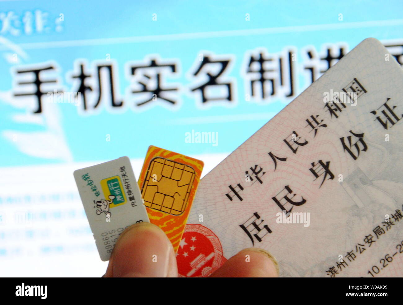 A Chinese mobile phone user shows his SIM cards and ID card in Binzhou ...