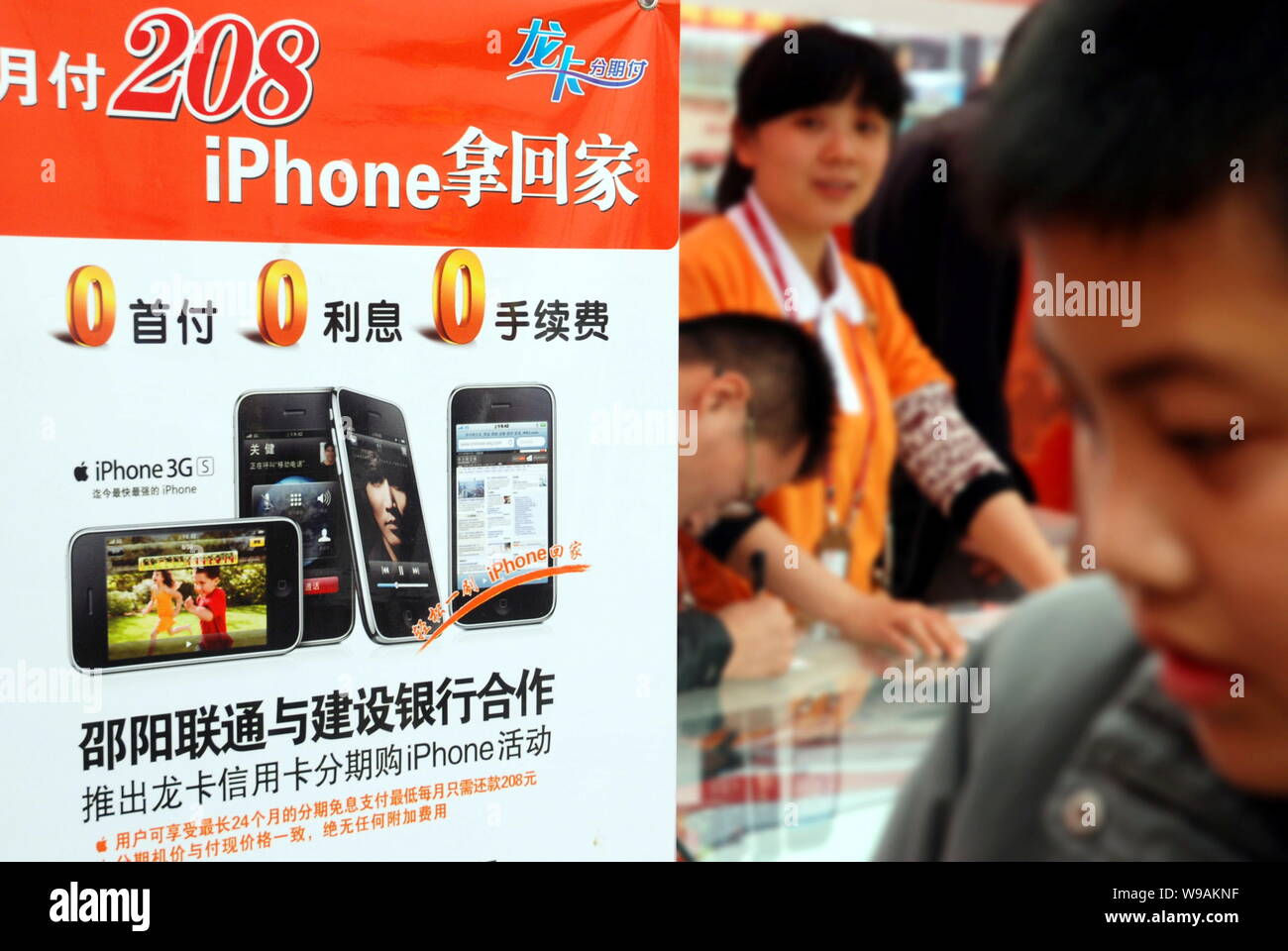 --FILE--A Chinese kid walks past an advertising poster for iPhone 3GS ...