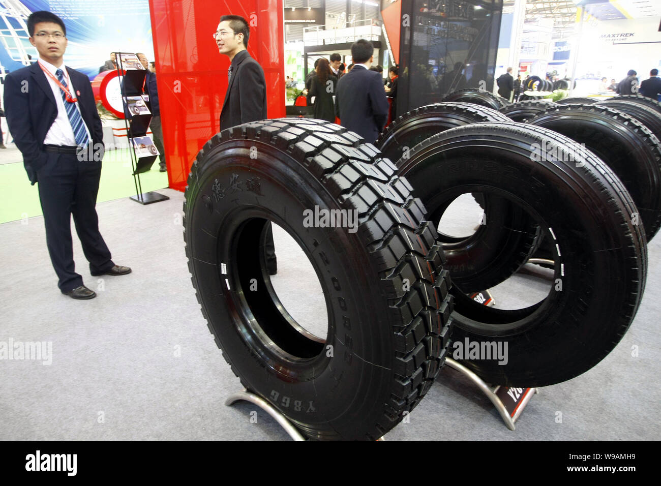 --FILE--Chinese staff stand next to tires on display during the ...