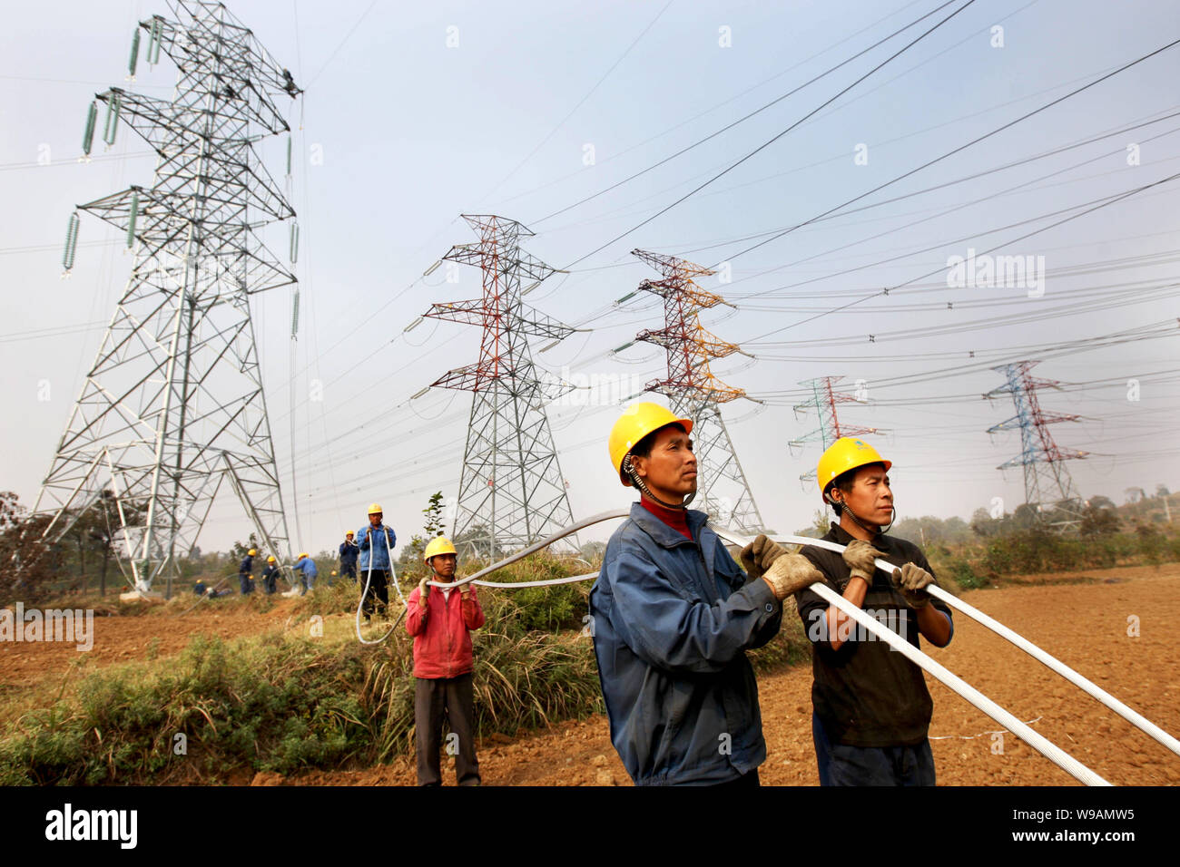--FILE--Chinese electricians mount high-voltage power lines on pylons ...